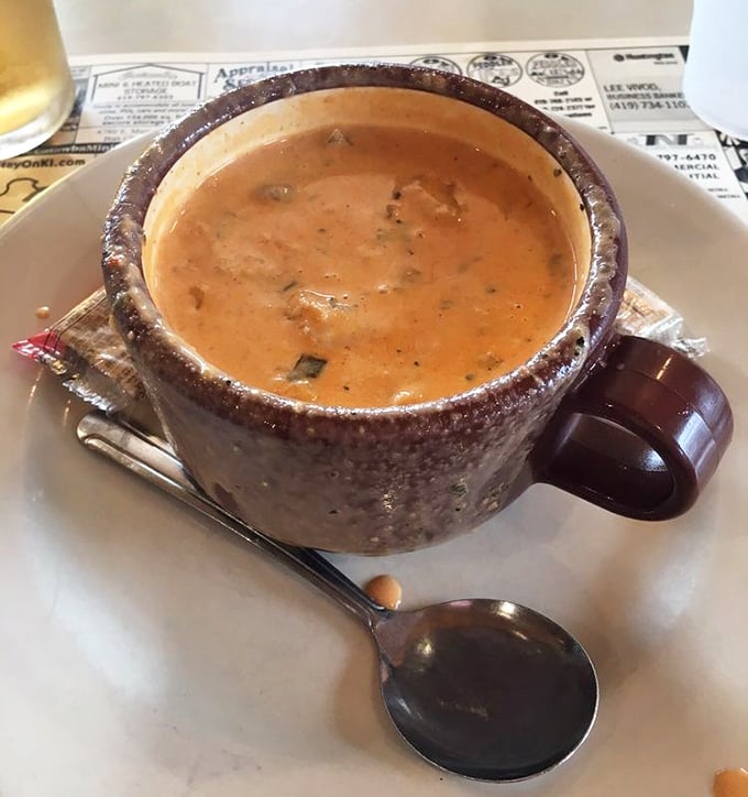 The lobster chowder arrives in a rustic ceramic mug – creamy, hearty, and packed with enough seafood to make you temporarily forget you're in Ohio.