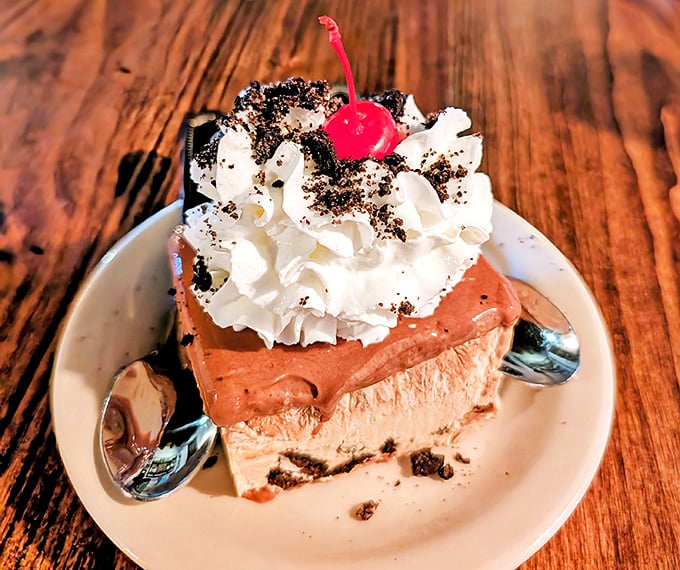This isn't just dessert—it's architecture. Layers of chocolate mousse and cream topped with a cherry that's clearly living its best life.