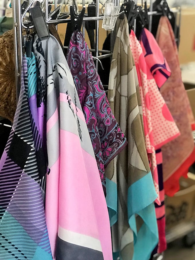 Silk scarves hanging like colorful flags of tiny nations, each representing a different fashion era and personality.