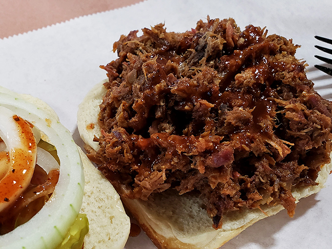 The pulled pork sandwich – where smoke-infused meat meets soft white bread in a romance that's been going on since barbecue began.