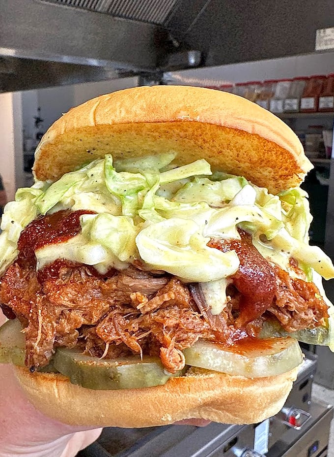 This pulled pork sandwich doesn't just have layers of flavor—it has chapters, subplots, and a surprise ending that involves napkins and happiness.