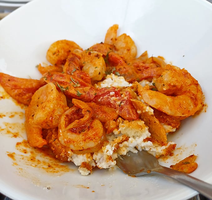 The legendary shrimp and grits – plump crustaceans lounging on a creamy bed of corn perfection. This dish alone justifies the drive to Cornelia.