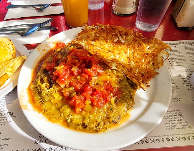 This isn't just an omelet—it's an architectural marvel of eggs, melted cheese, and fresh salsa. The crispy hash browns standing guard are non-negotiable.