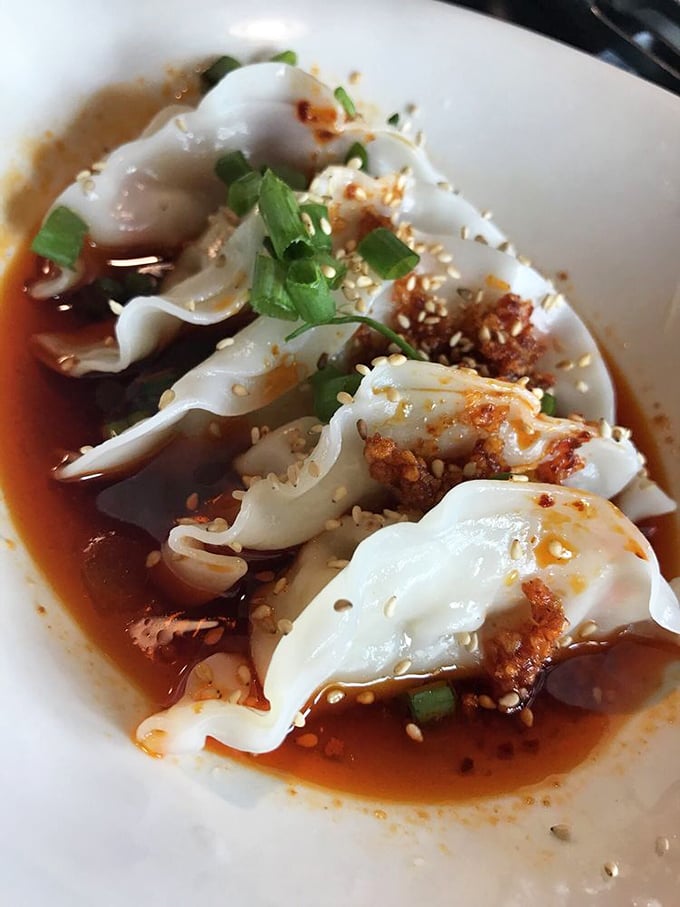 These aren't just dumplings—they're little pillows of joy bathing in a sauce so good you'll want to bottle it.