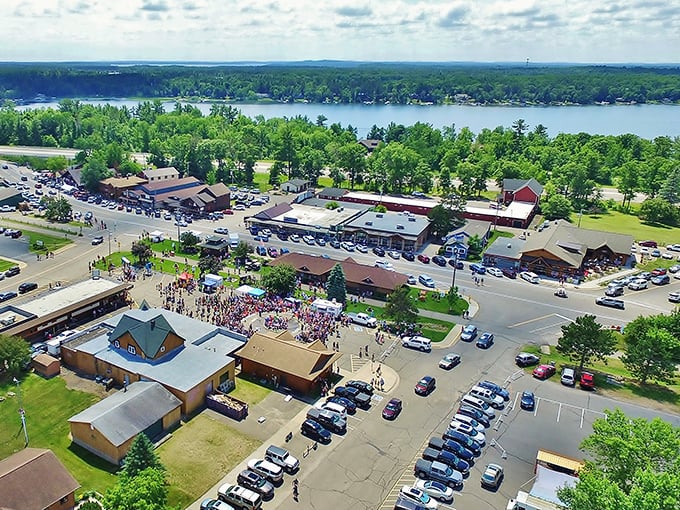 Aerial view of shops and parking lots buzzing with activity—small-town commerce with big-time lake country appeal.