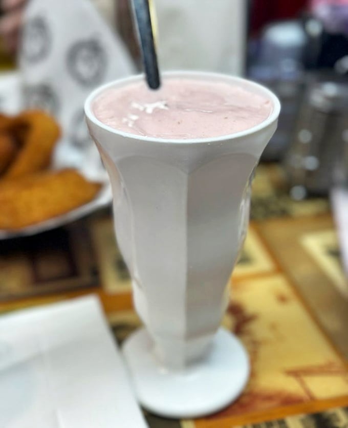 A banana cherry shake so thick you'll get an arm workout with your dessert – the straw stands at attention like it's afraid to fall in.