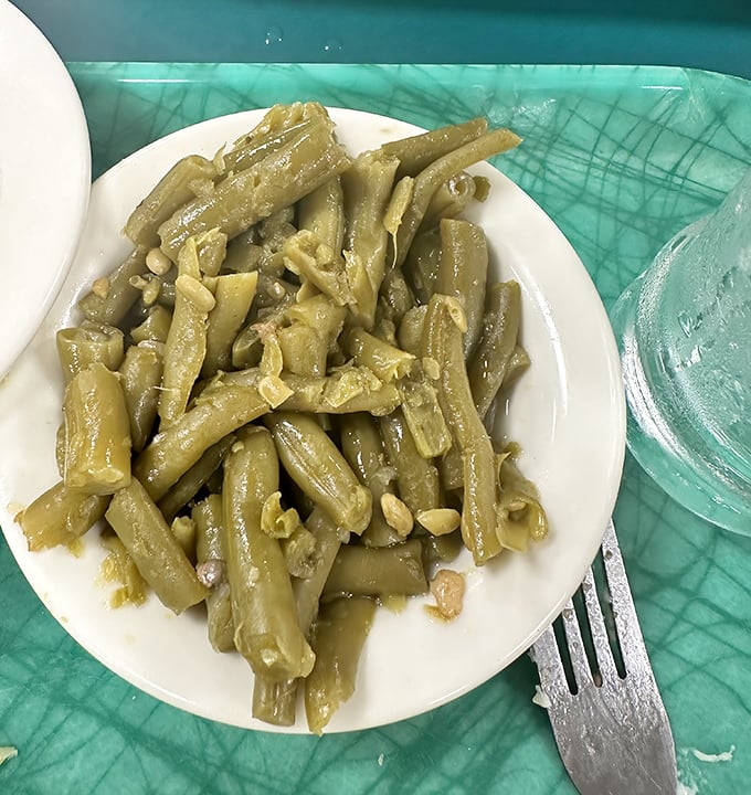 These green beans, cooked Southern-style with bits of ham, have clearly been simmering since sometime last Tuesday – exactly as they should be.