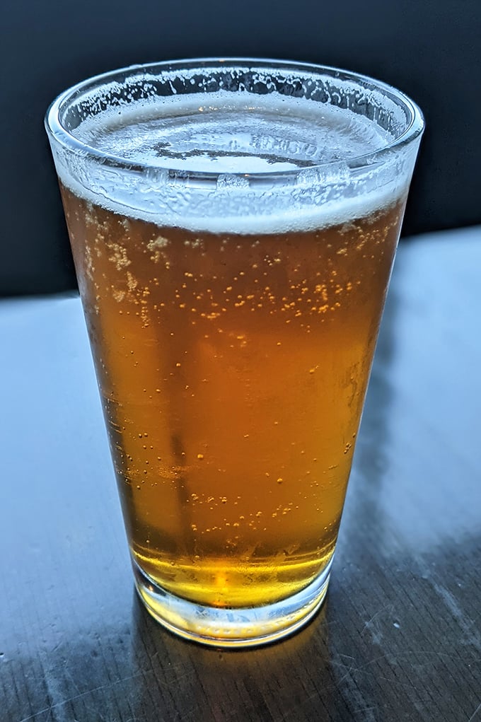 This isn't just beer—it's liquid amber sunshine in a glass, the perfect companion to tame the beast of a burger you just ordered.