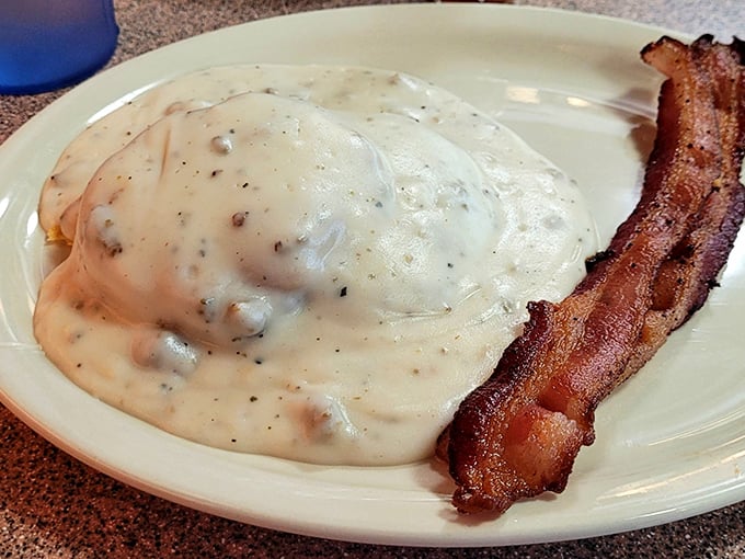Biscuits and gravy—the breakfast that hugs you from the inside. That crispy bacon standing at attention is just showing off.