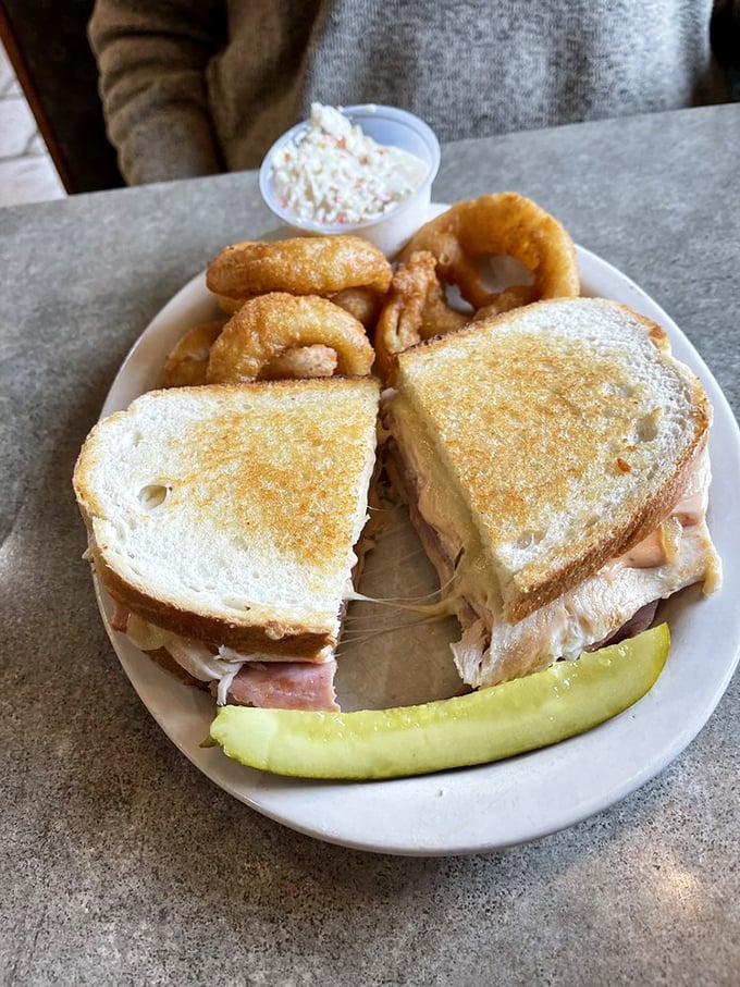 This sandwich isn't just lunch – it's architectural genius stacked between bread with onion rings playing the supporting role they were born for.