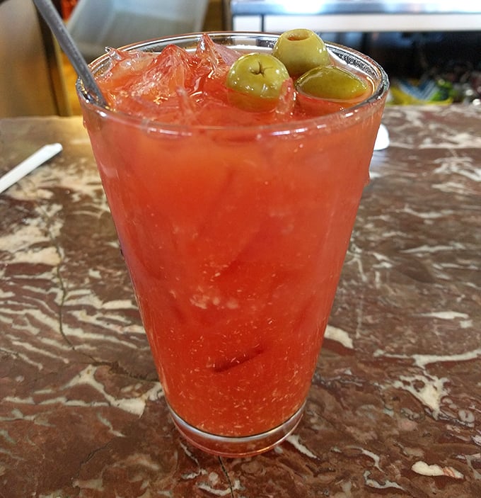 A Bloody Mary garnished with olives—the breakfast of champions' liquid sidekick. That vibrant red promises both virtue (tomato) and vice (vodka).