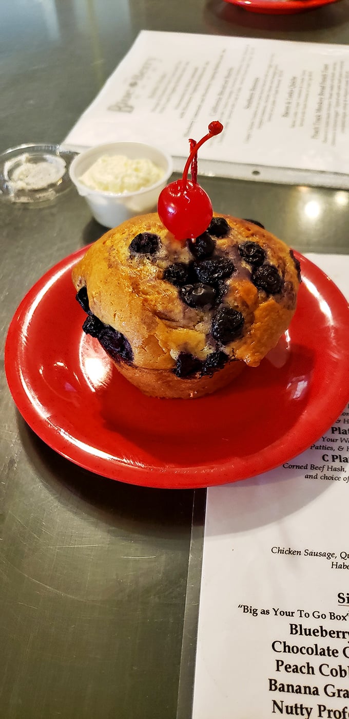 This blueberry muffin, crowned with a cherry sentinel, isn't just breakfast—it's a morning celebration that makes Monday feel like Saturday.