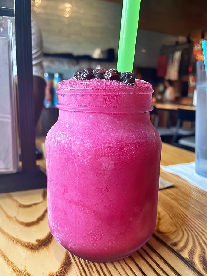 That vibrant purple moonshine looks like it could either cure what ails you or give you superpowers. Either way, you're in for an interesting evening.