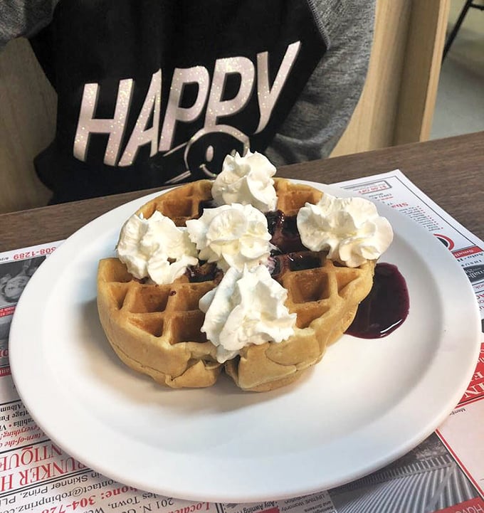 Blueberry waffle crowned with whipped cream and syrup: the kind of sweet start that makes alarm clocks worthwhile.