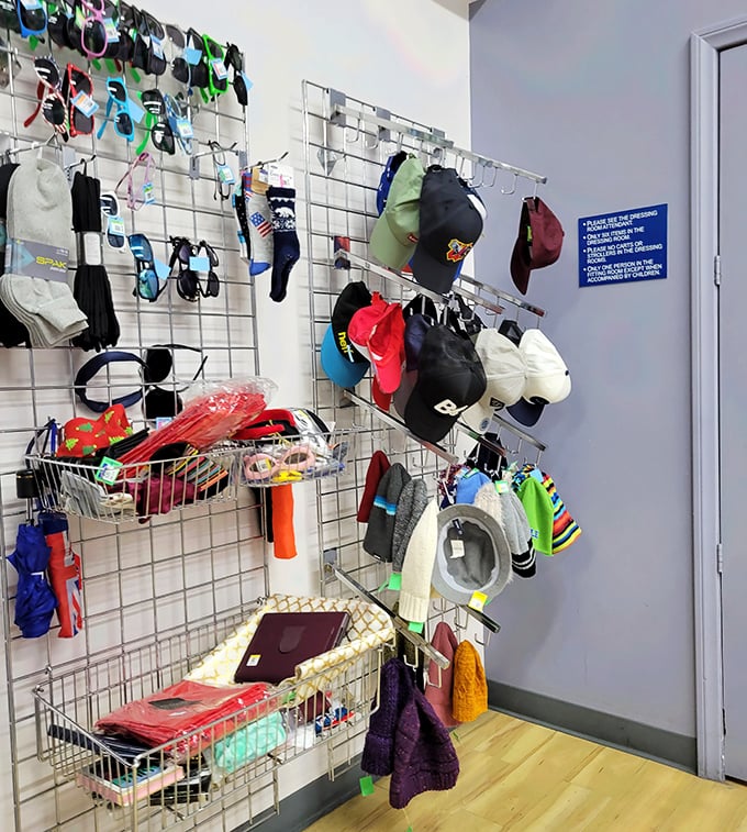 The accessories wall: a gallery exhibition of practical art where baseball caps and winter beanies create a colorful mosaic.