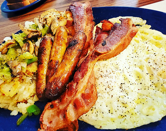 The breakfast trinity—crispy bacon, golden eggs, and home fries—proof that sometimes the simplest combinations are culinary perfection.