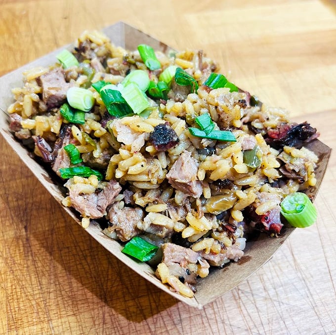 Brisket dirty rice – where Texas smoke meets Louisiana soul in a cardboard boat that should be enshrined in a food museum.