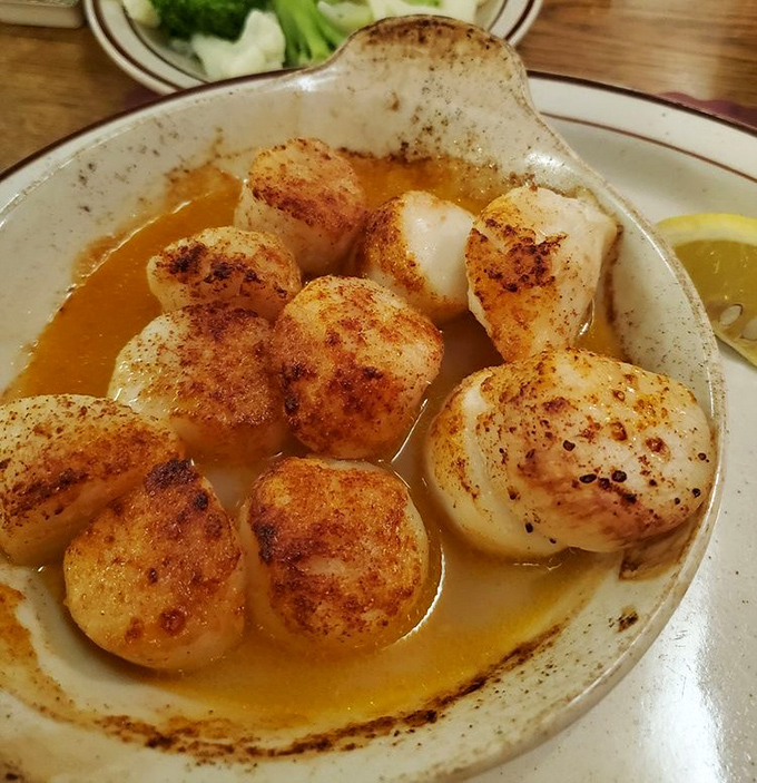 Broiled scallops swimming in butter sauce—where each perfectly caramelized morsel delivers that sweet ocean flavor that makes you momentarily forget you're in Ohio.