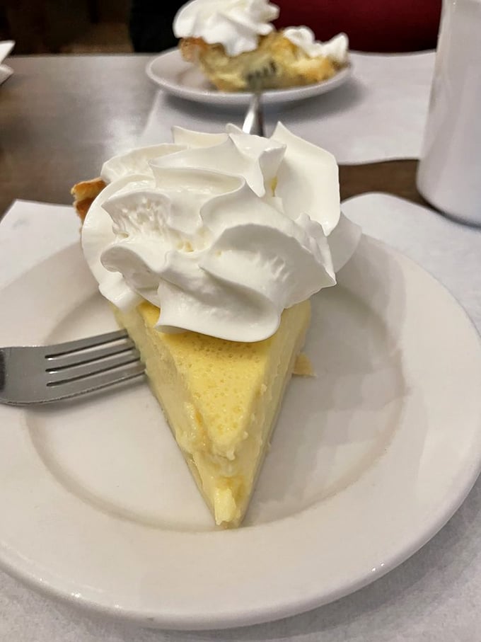 Buttermilk pie topped with a cloud of whipped cream—the kind of dessert that makes you understand why people used to sit on porches and just be content.