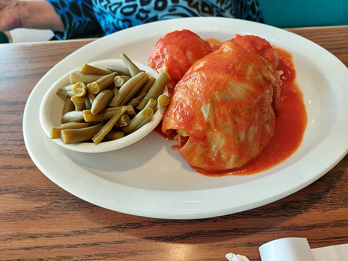 Cabbage rolls swimming in bright tomato sauce with green beans on standby—comfort food that grandmothers everywhere would approve of.