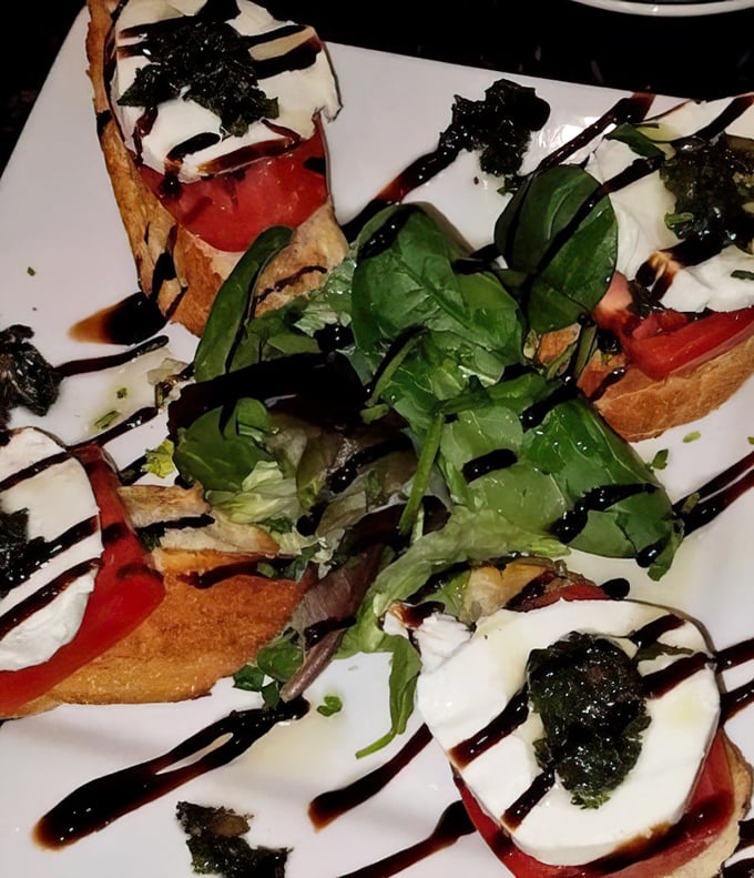 Caprese bruschetta with a dramatic balsamic drizzle—proof that sometimes the simplest combinations create the most memorable flavors.