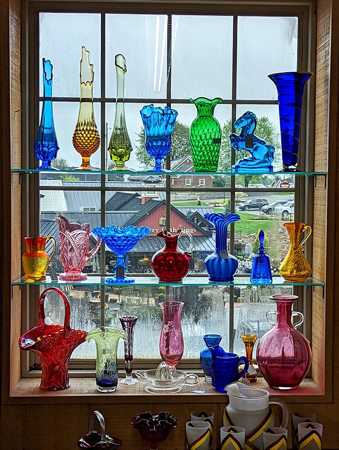 Sunlight transforms this carnival glass display into a kaleidoscope of blues and reds—each piece holding memories of county fairs past.