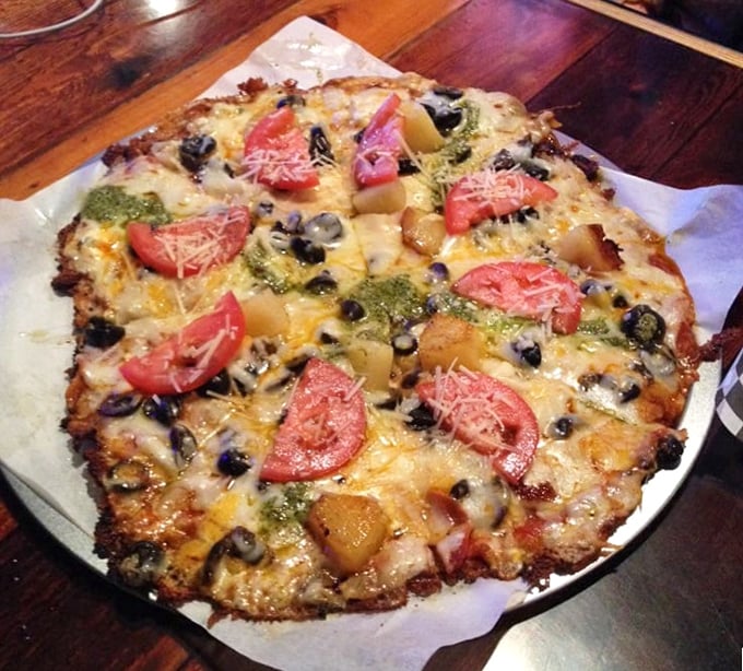 This isn't just pizza—it's a cheese-crusted revelation topped with fresh tomatoes and olives that somehow makes you feel virtuous while indulging. 