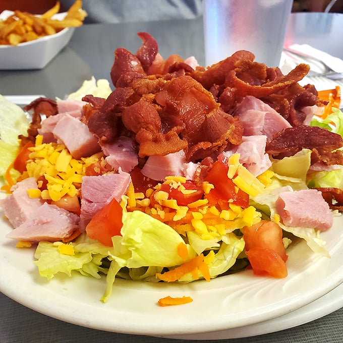 A chef salad that somehow makes vegetables feel indulgent. That bacon crumble isn't health food—it's happiness in crispy form.