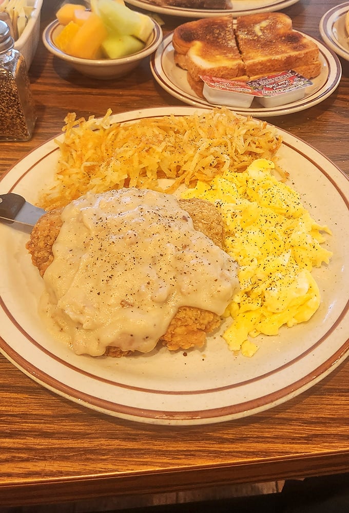 Chicken fried steak smothered in gravy alongside scrambled eggs and hash browns—the breakfast equivalent of a warm hug from your favorite aunt.