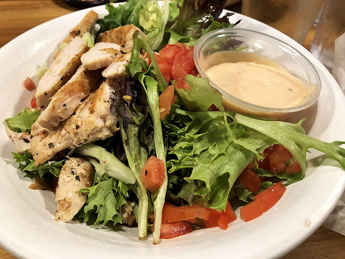 Even the salads get the zombie treatment—fresh greens and grilled chicken proving that surviving the apocalypse doesn't mean skipping vegetables.