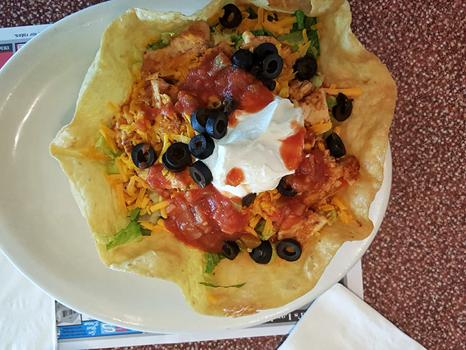This taco salad bowl isn't just lunch—it's edible architecture, a crispy fortress protecting a kingdom of cheese, olives, and seasoned protein.