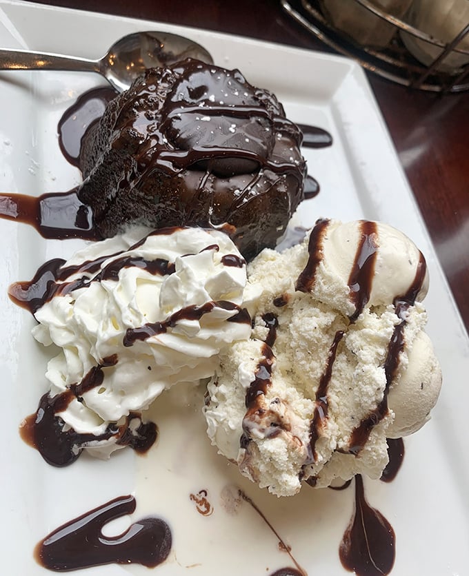 This chocolate lava cake doesn't just break open—it performs a dramatic reveal worthy of a Broadway finale, complete with ice cream co-stars.