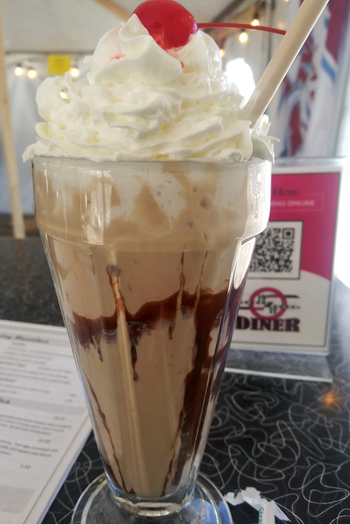 Chocolate malt topped with whipped cream and a cherry—the kind of nostalgic indulgence that makes adults remember why being a kid was awesome.