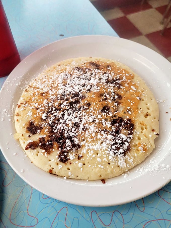 This chocolate chip pancake isn't just breakfast—it's therapy on a plate, with a dusting of powdered sugar for good measure.