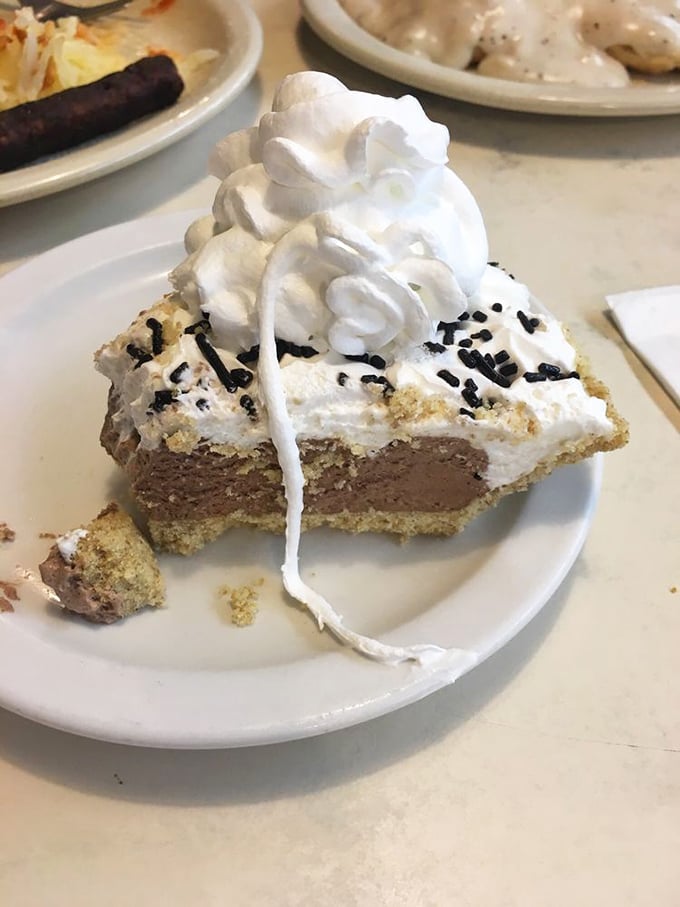 A slice of chocolate cream pie topped with a mountain of whipped cream—because sometimes more is exactly the right amount.