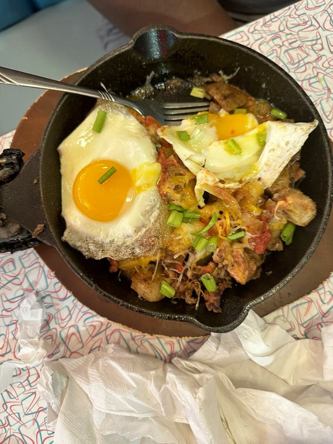 That sizzling skillet arrives like a rockstar on stage—eggs sunny-side up crowning a spicy fiesta underneath.