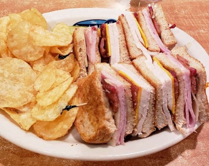 A club sandwich that towers like a skyscraper of flavor. Those house-made chips aren't just a side—they're a statement.