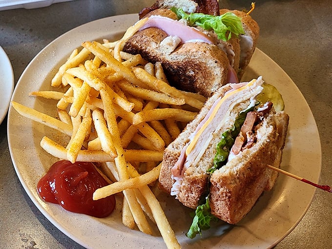 The club sandwich—architecture you can eat—stacked high with layers of deli meat, crisp lettuce, and the perfect ratio of mayo to toast.