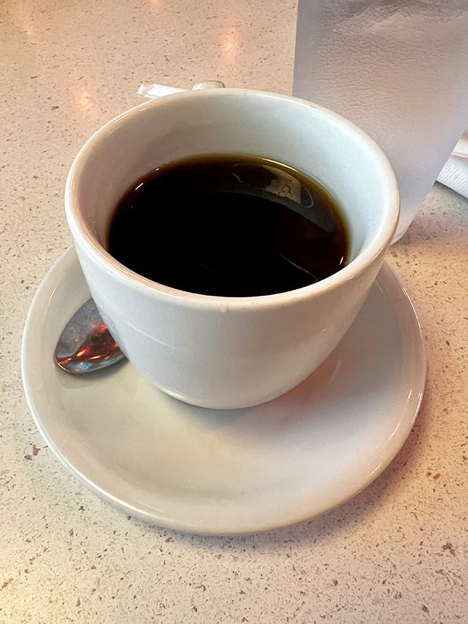 Simple black coffee in a white cup—no foam art, no fancy names, just the liquid courage that's launched a million mornings.