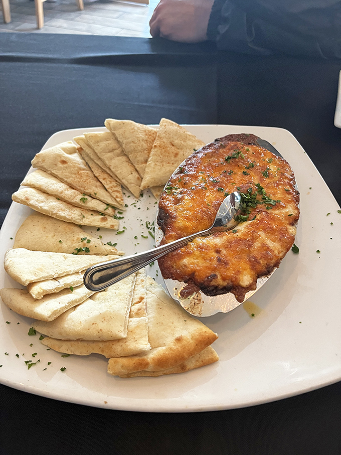 Bubbling crab dip with warm pita triangles—the kind of shareable that nobody actually wants to share. 