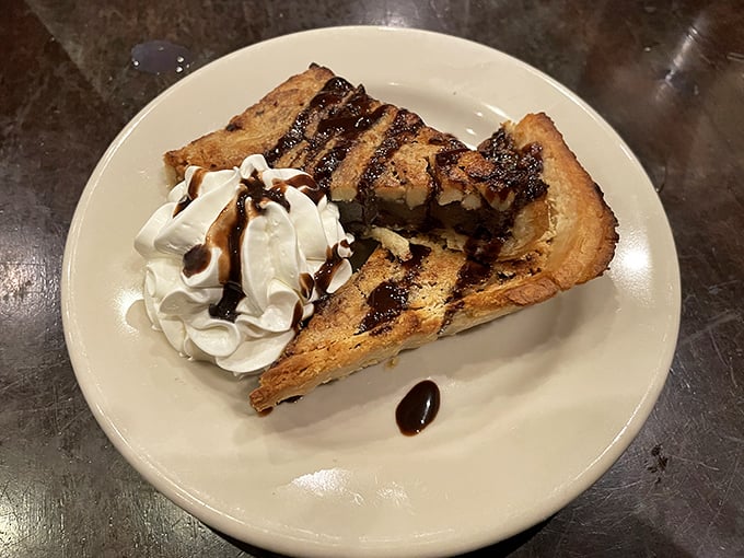 Not just dessert, but a Kentucky tradition. Warm pecan pie drizzled with chocolate and topped with whipped cream—fork-fighting territory for sure.