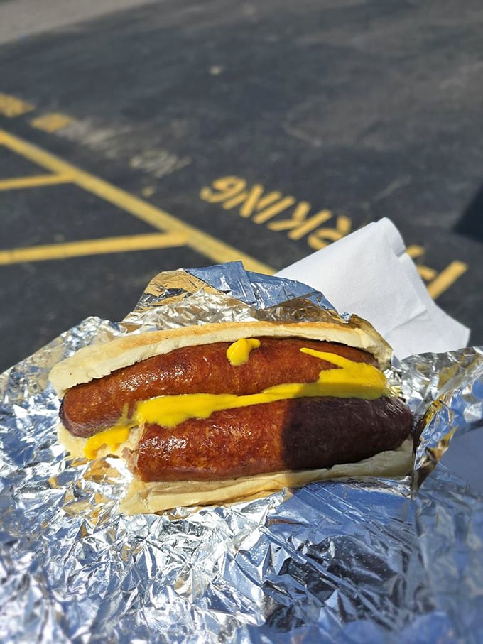 Two sausage links cradled in a soft roll with mustard—proof that sometimes the simplest pleasures deliver the most profound satisfaction.