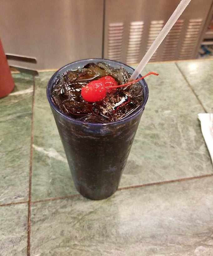 That cherry-topped soda isn't just a drink – it's liquid nostalgia served in a glass tall enough to hold childhood memories and adult-sized thirst.