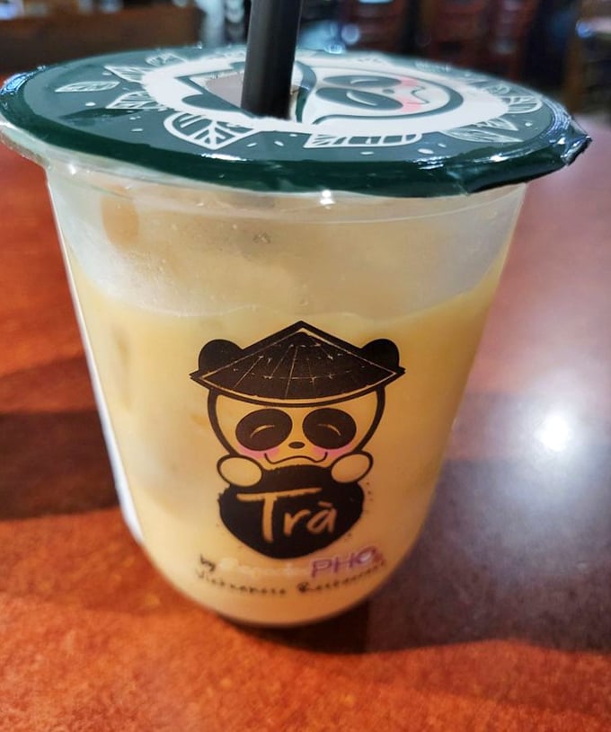 This isn't just a beverage—it's liquid sunshine in a cup, complete with an adorable panda mascot that seems to say, "Yes, you deserve this treat."