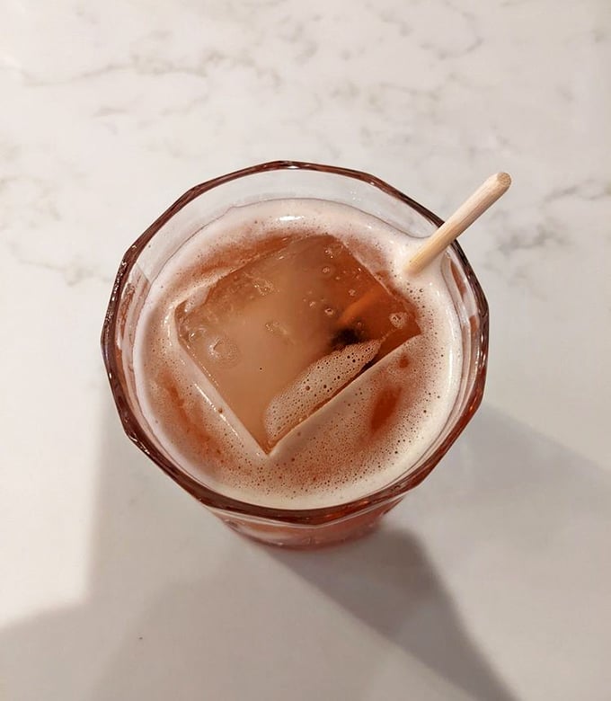 This isn't just a drink – it's a rosy-hued promise in a glass, complete with that satisfying ice cube that makes everything taste better.