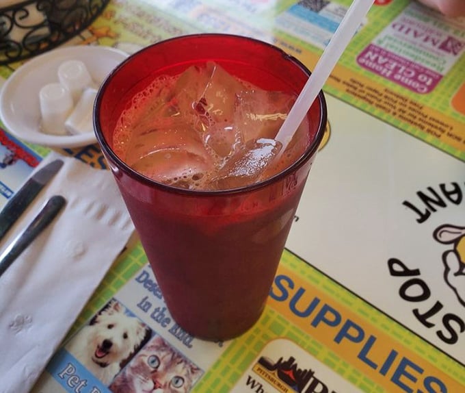 That ruby-red iced tea in its no-nonsense glass isn't just a beverage—it's the perfect supporting actor in your breakfast blockbuster.