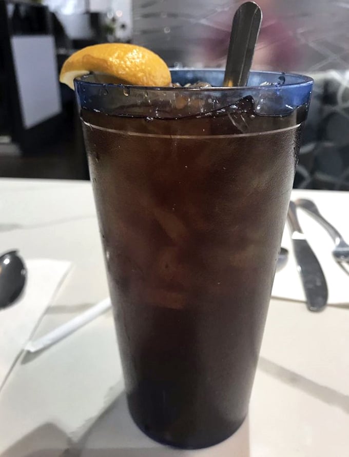 A tall glass of iced tea with lemon—the unofficial hydration station of diners everywhere and nature's perfect palate cleanser.