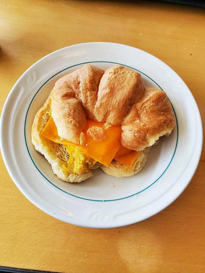 The humble breakfast croissant, elevated to art form—golden, flaky exterior giving way to melted cheese and egg that makes morning meetings almost bearable.