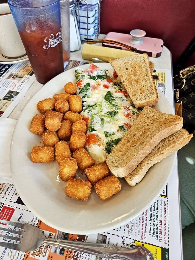 Breakfast architecture at its finest. Golden tater tots, a perfectly folded omelet, and fresh fruit create the breakfast trifecta of champions.