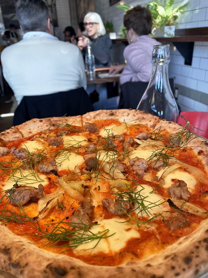 Sausage, fennel, and fresh herbs dance across a perfectly charred crust. It's the pizza equivalent of a perfectly tailored Italian suit – effortlessly sophisticated.